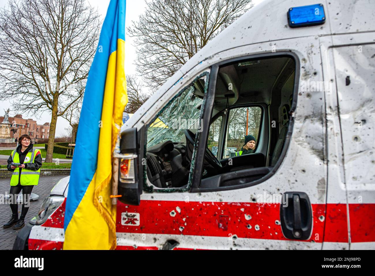 Two Ukrainian volunteers are seen taking a look at the destroyed ...