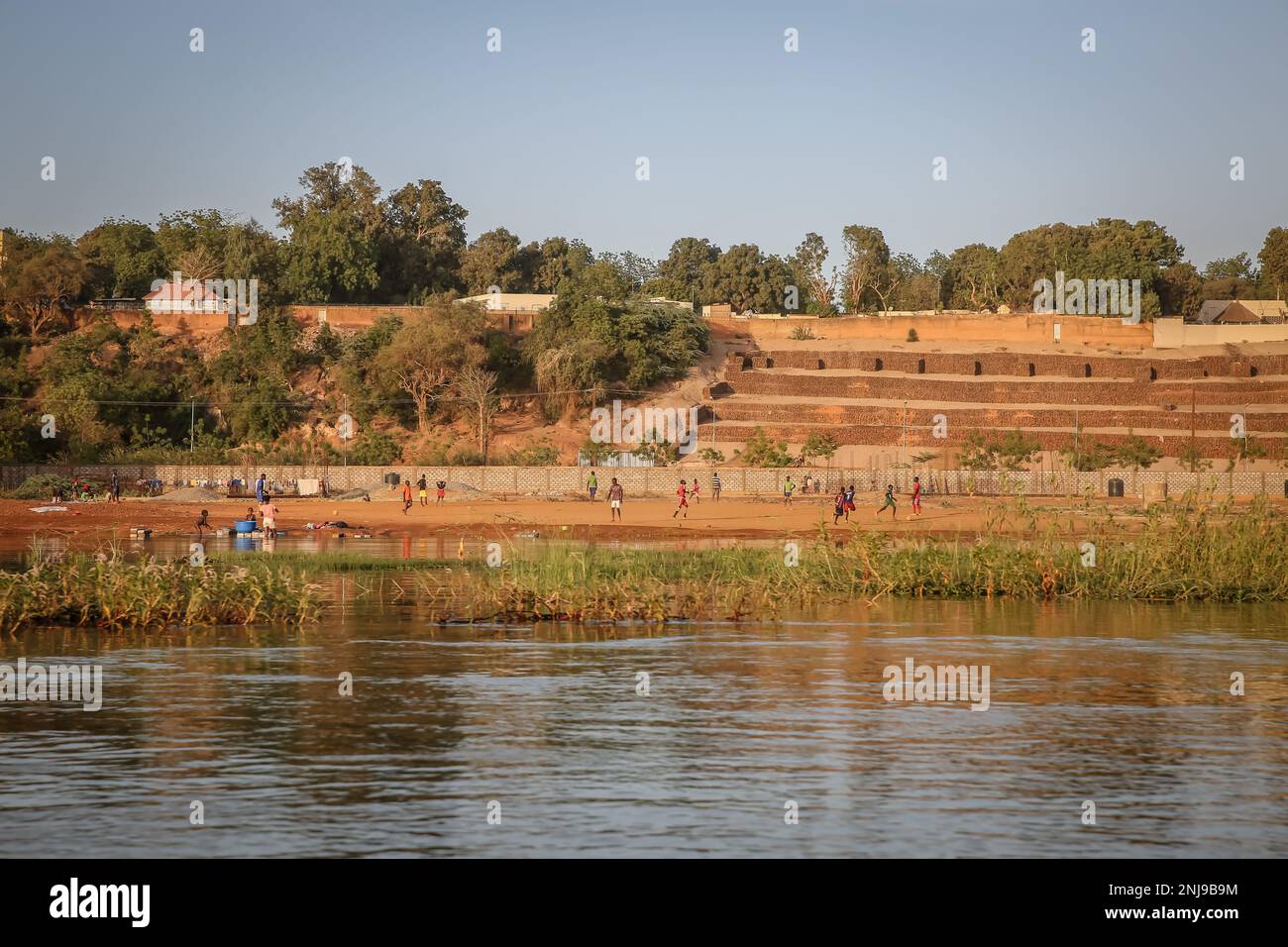 Children seen playing football along the bank of the Niger River in ...