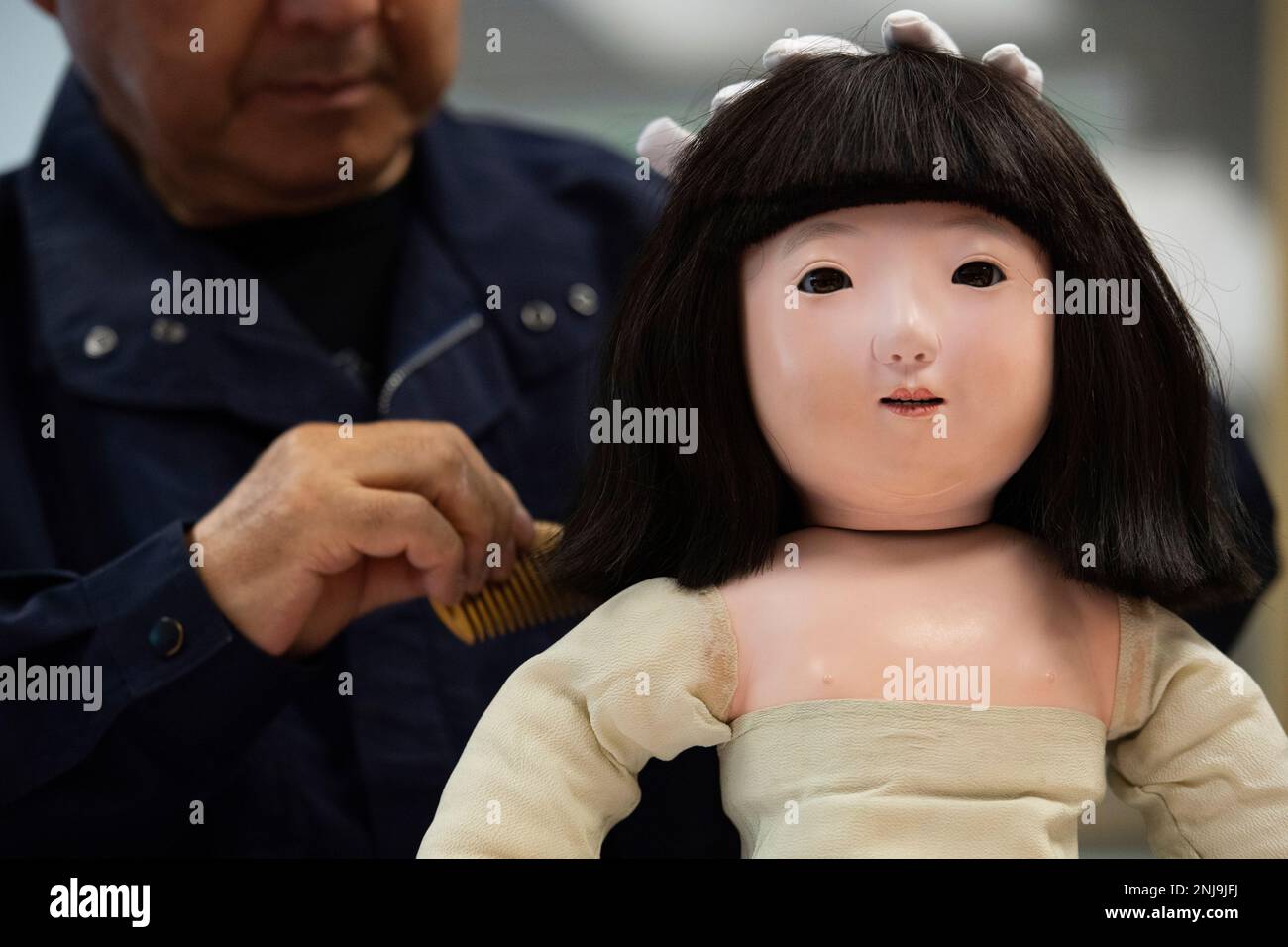 Mr. Aoki, left, works on 95-year-old Japanese Friendship Doll, Miss Mie ...