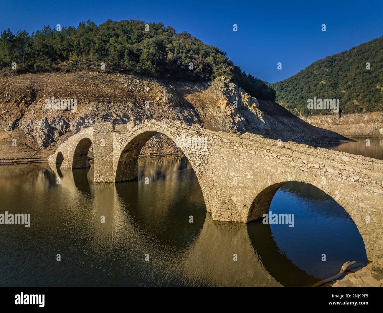 Aerial view of the medieval bridge of Querós, in the Susqueda reservoir ...