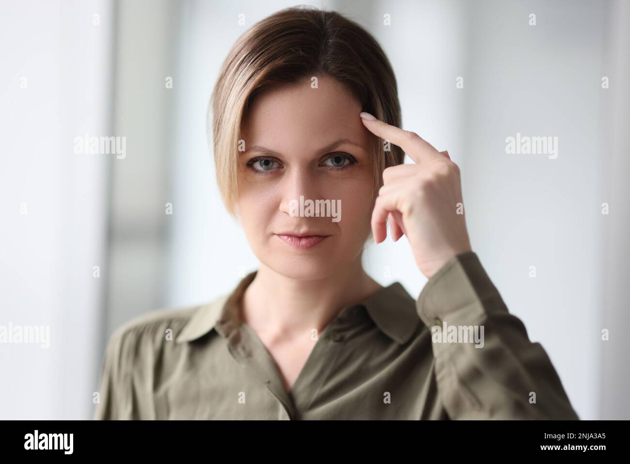Portrait of a thinking woman with a finger on the forehead Stock Photo ...