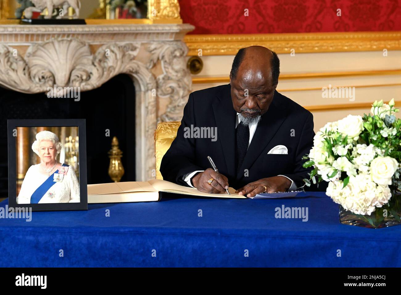 Former Mozambique President Joaquim Chissano signs a book of ...