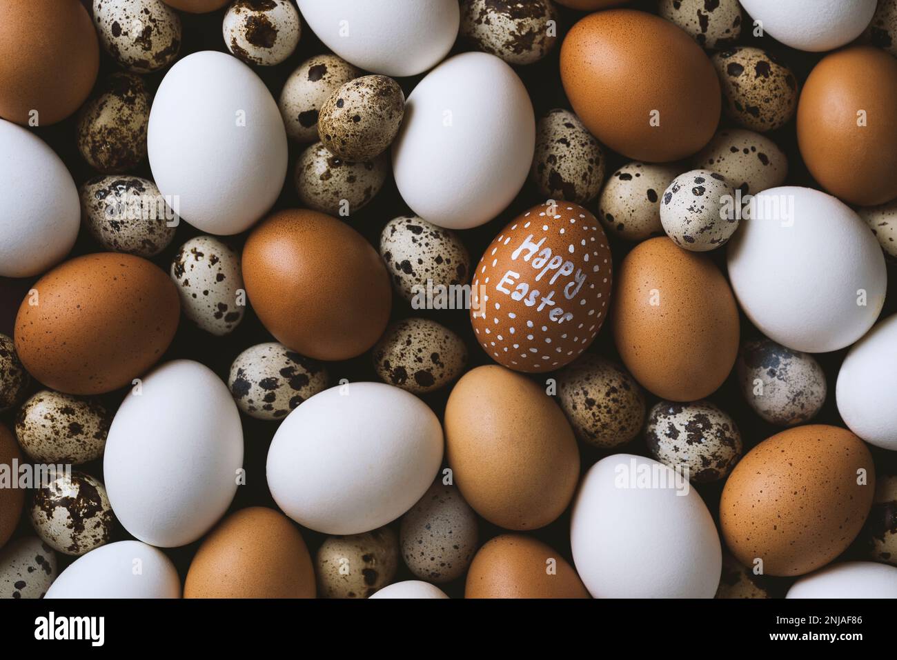Happy easter written white chicken egg on pile of eggs. Stack of brown ...