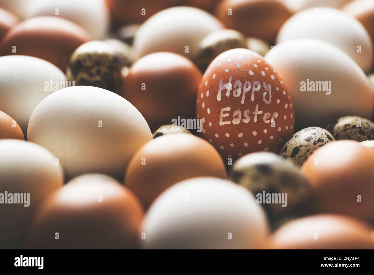 Happy easter written white chicken egg on pile of eggs. Stack of brown ...