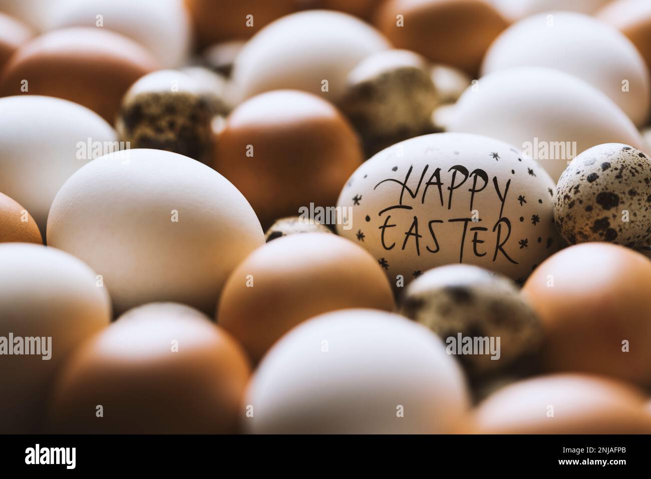 Happy easter written white chicken egg on pile of eggs. Stack of brown ...