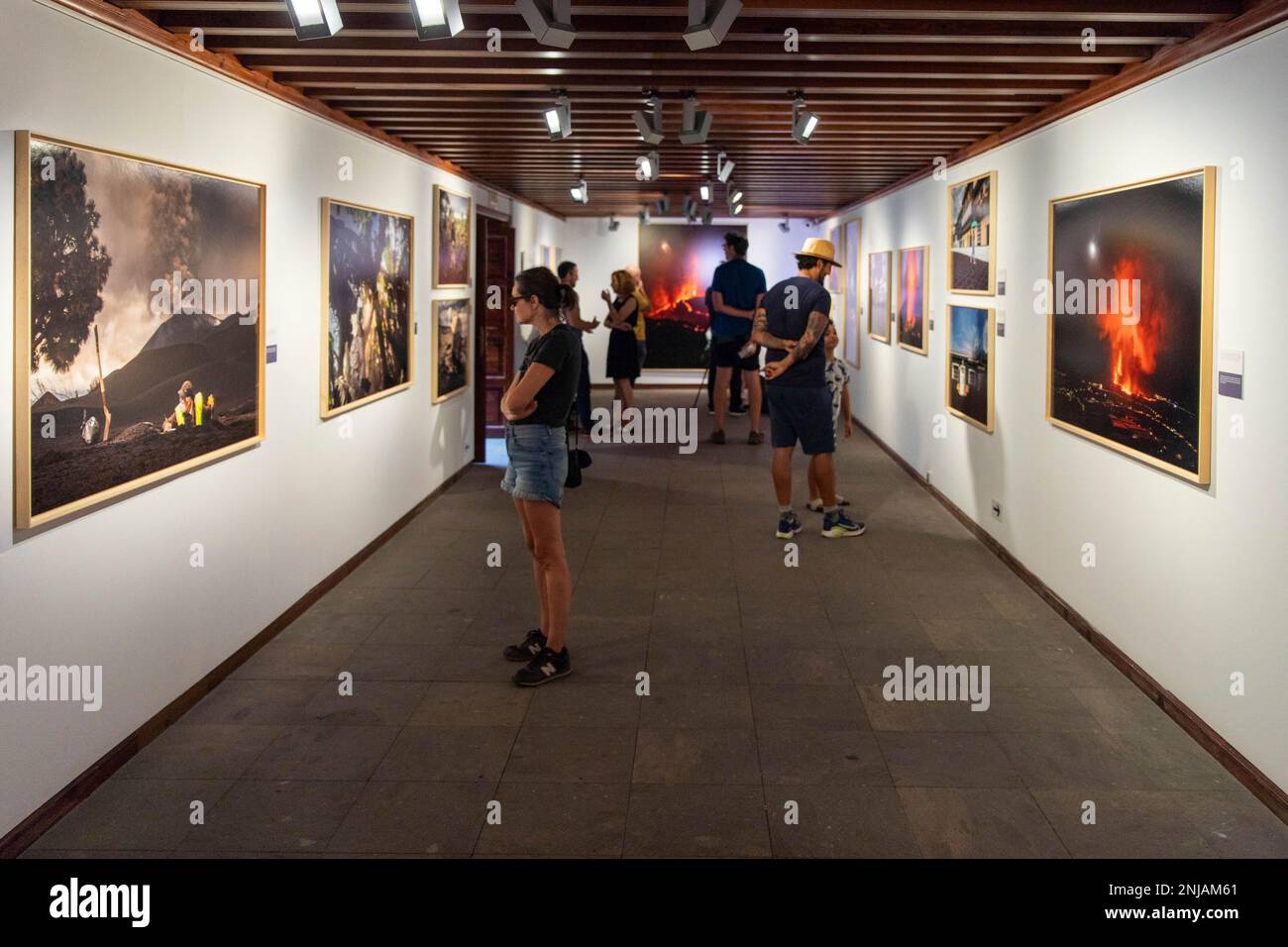 Several people look at the images of photographer Arturo Rodriguez at ...