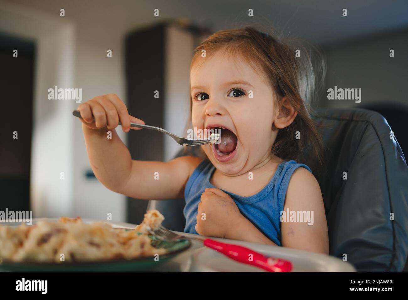 Caucasian young little adorable baby girl sitting on children chair ...
