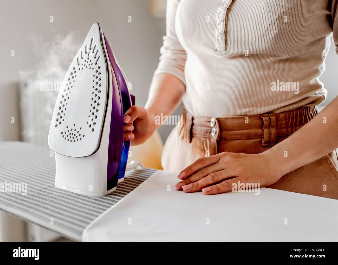 Female hand using steam iron hi-res stock photography and images - Alamy
