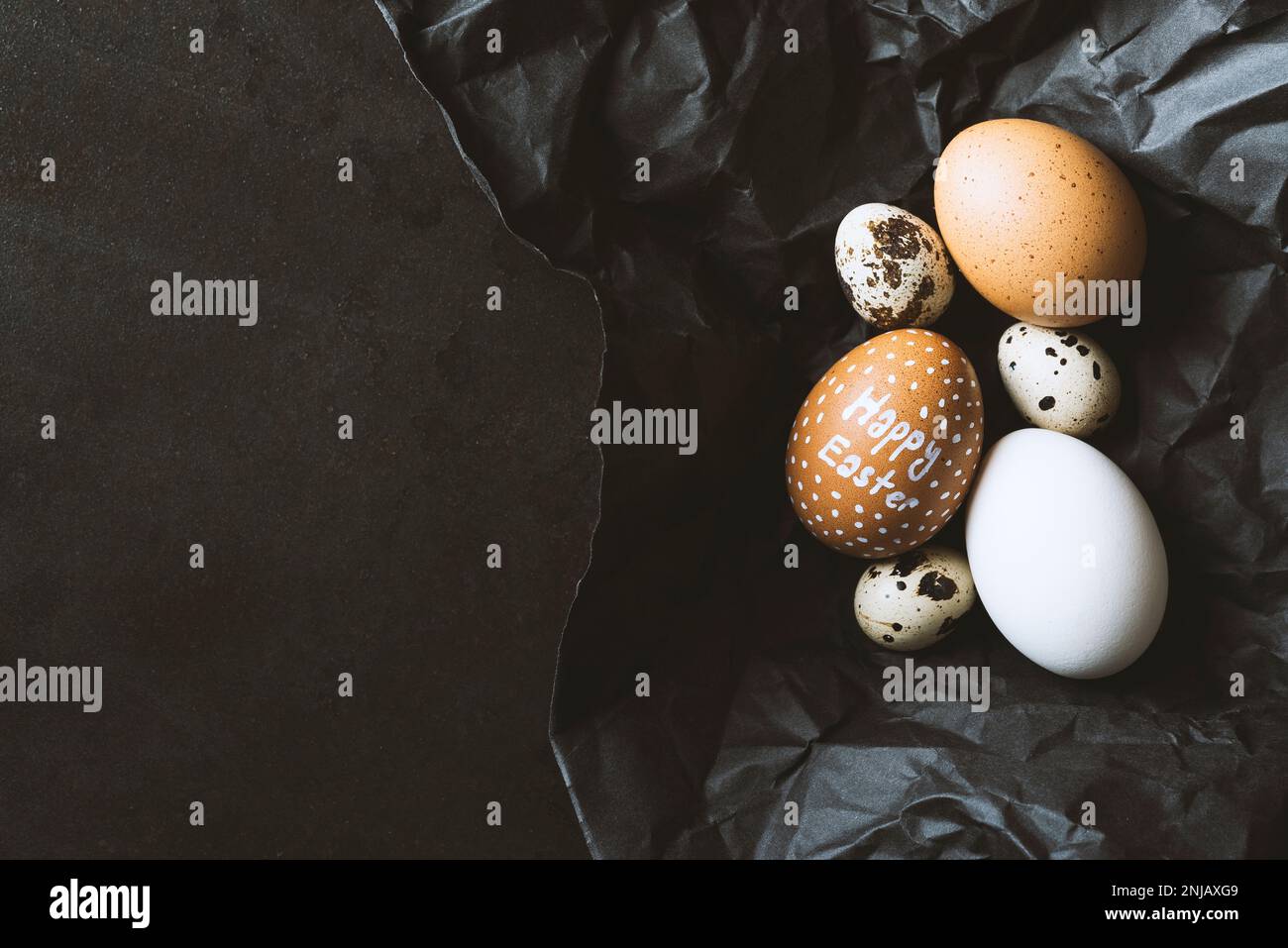 Happy easter written egg with chicken and quail eggs wrapped in black ...