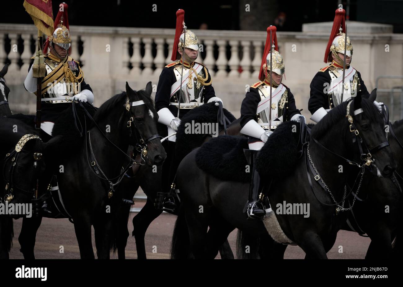 Mounted guards head down The Mall towards Buckingham Palace from where ...