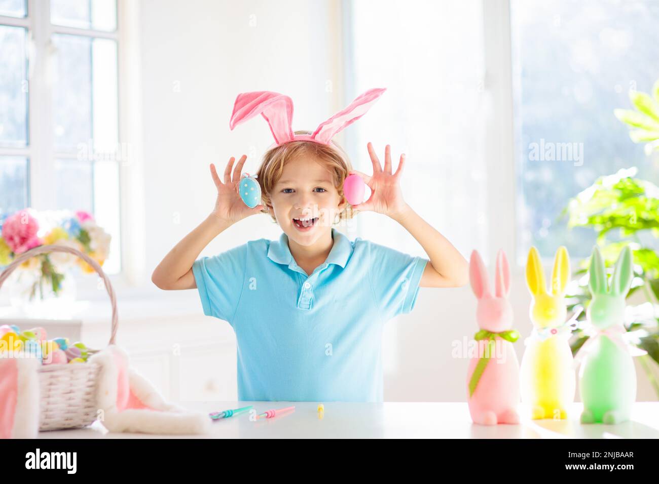 Kids dyeing Easter eggs. Children in bunny ears dye colorful egg for ...