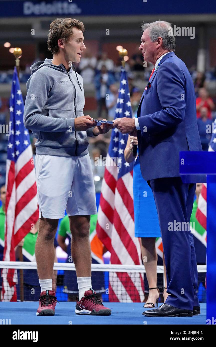 Casper Ruud is presented the trophy by USTA President, Mike McNulty ...