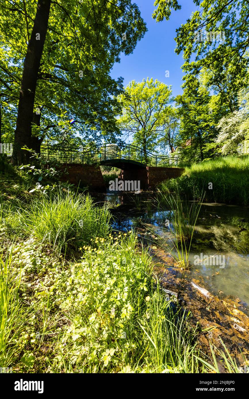 Old renovated retro bridge with green metal railings over small river ...