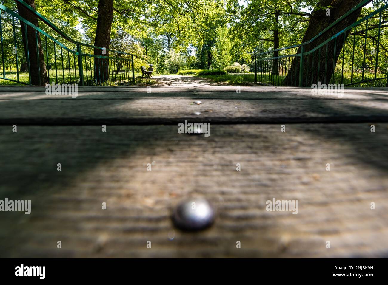 Old renovated retro bridge with green metal railings over small river ...