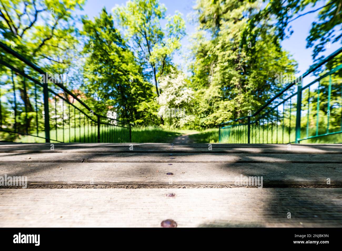 Old renovated retro bridge with green metal railings over small river ...