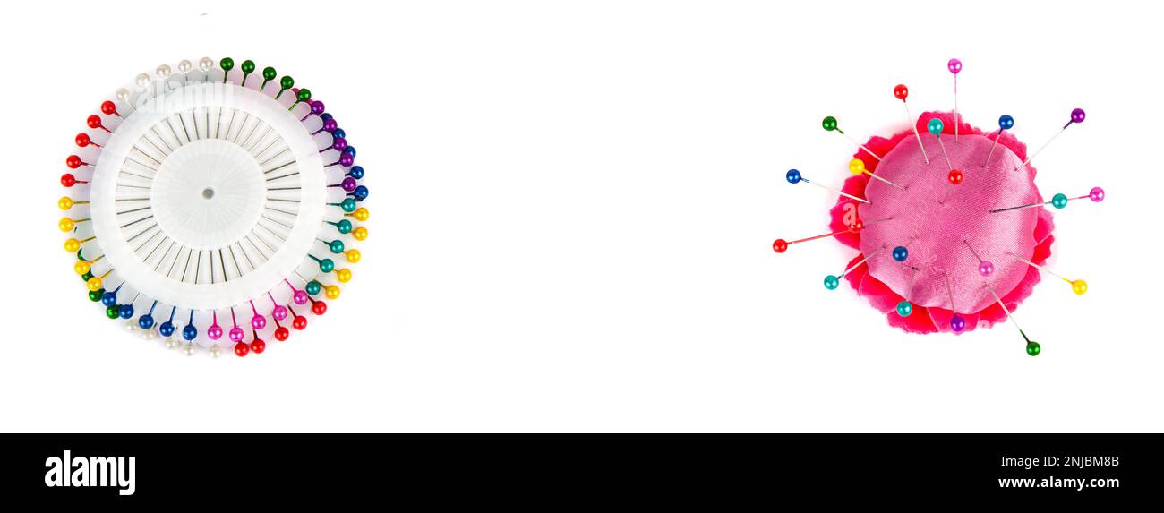 A set of multi-colored pins and a pincushion isolated on a white ...