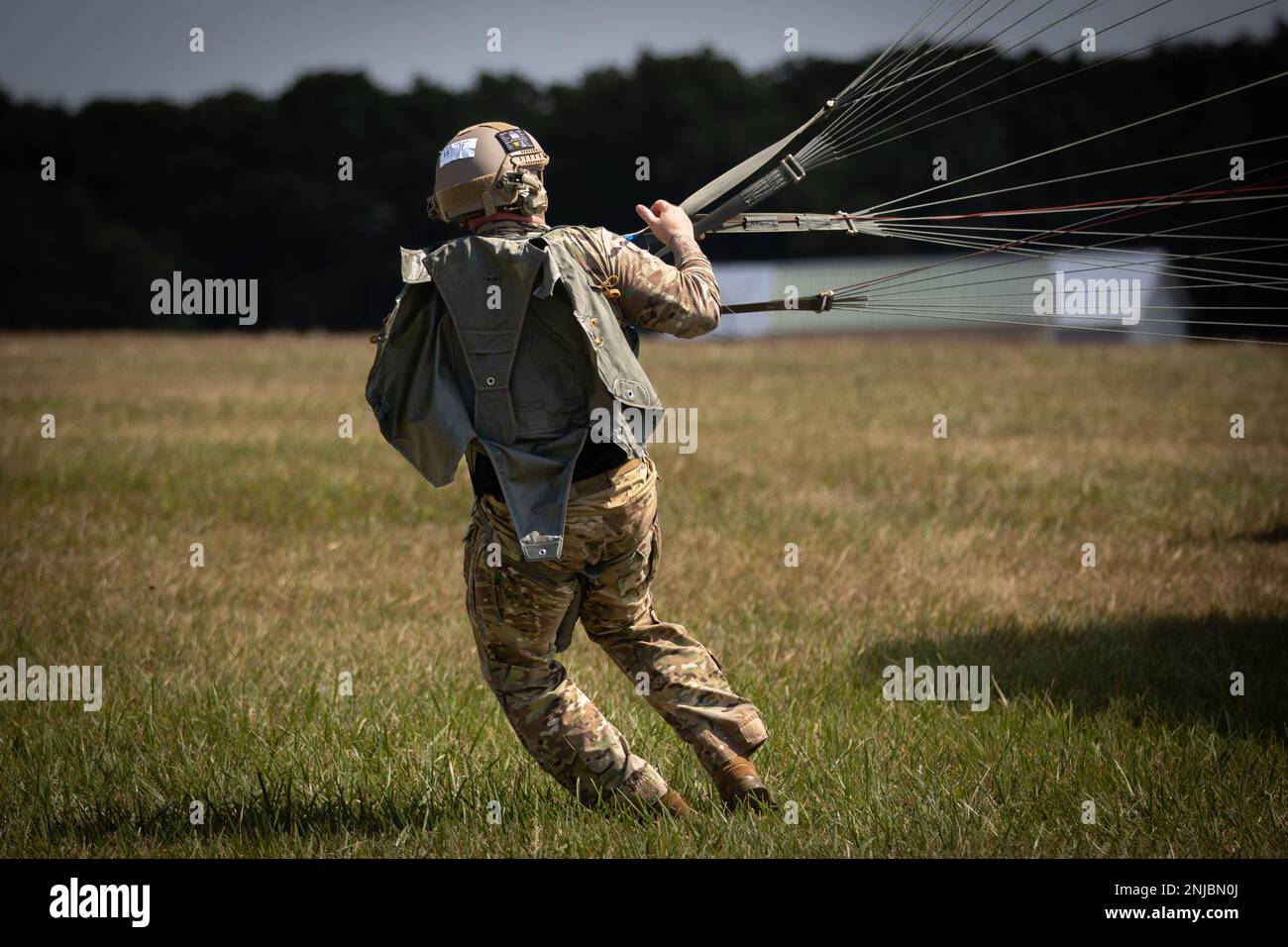 A U.S. Army Paratrooper runs and drags his MC-6 parachute towards the ...