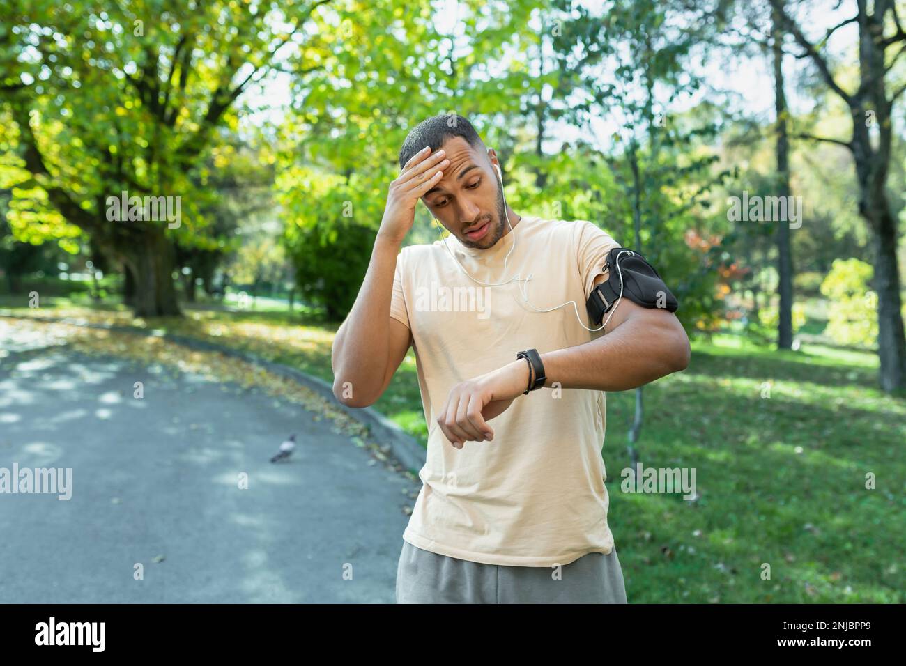 Young African American man runner, athlete in the park. A tired man ...