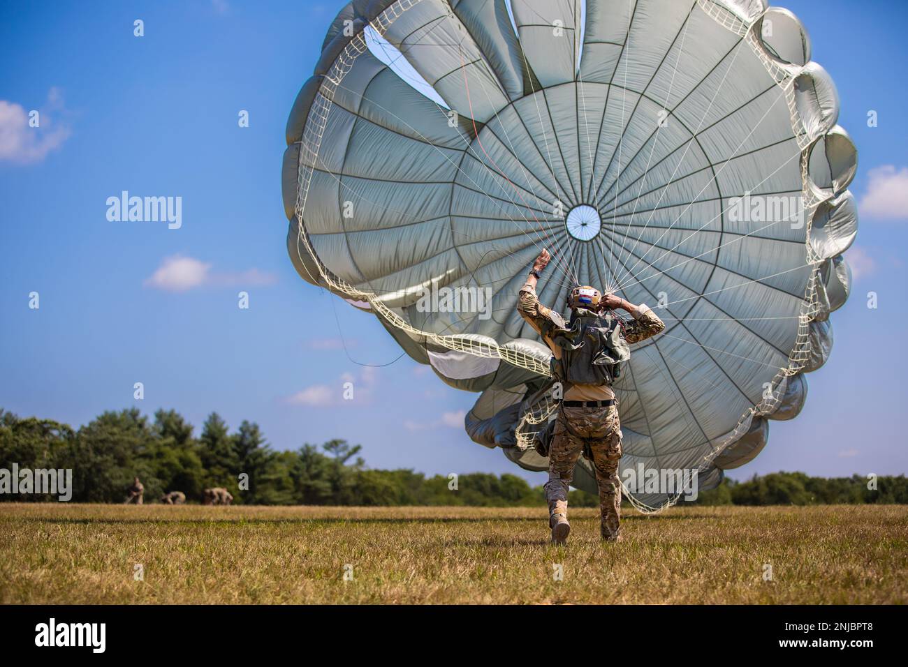 A Dutch Paratrooper drags his MC-6 parachute towards the objective on ...