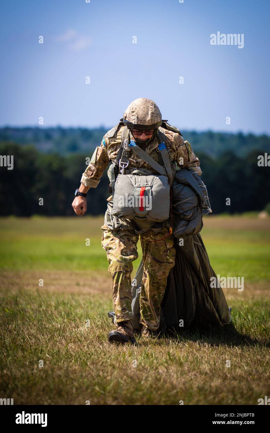 A British Paratrooper runs and drags his MC-6 parachute towards the ...
