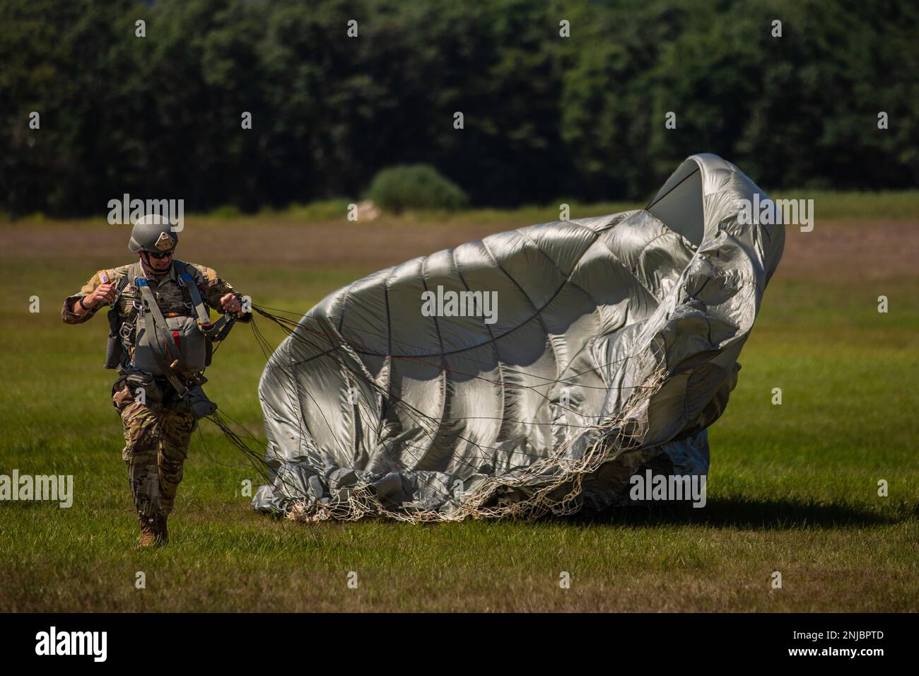 A U.S. Army Paratrooper runs and drags his MC-6 parachute towards the ...