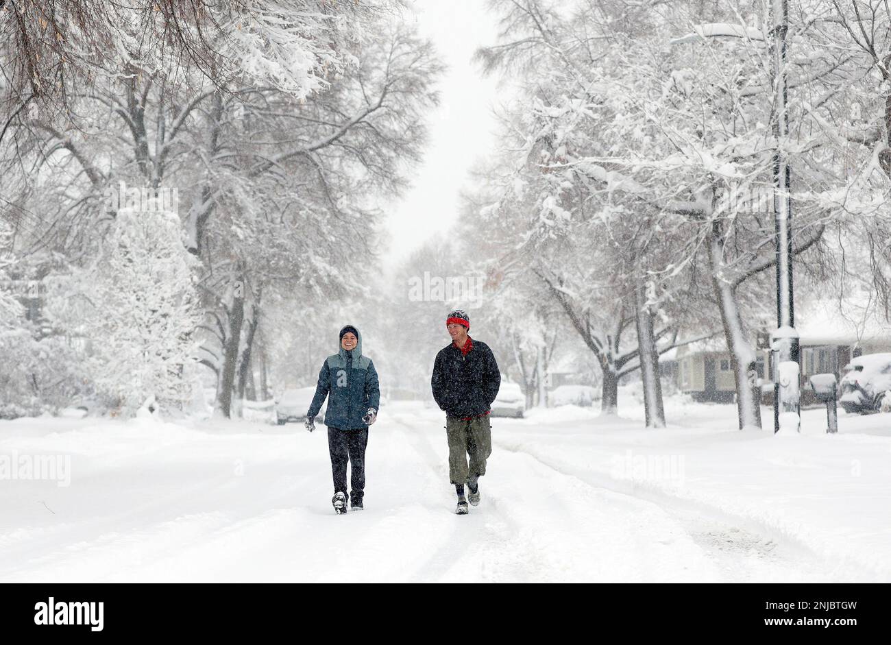 Katya Brooun and Jack Schill walk on an unplowed road during a ...