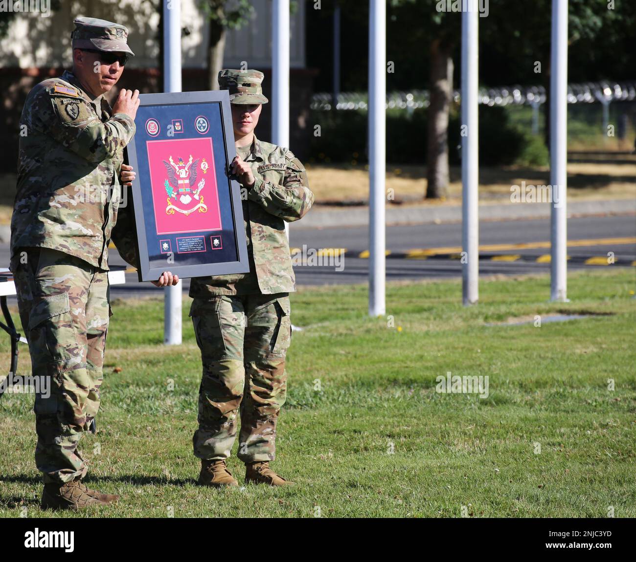 LTC Dan Raymond, displays a gift during the change of command ceremony ...