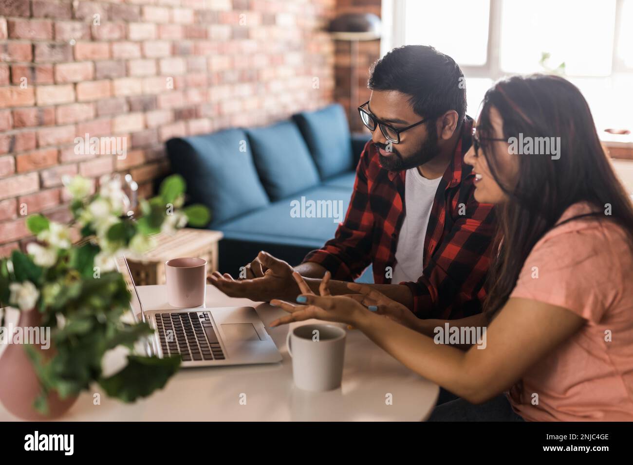 Happy indian family couple cuddle at desk make video call to friends ...