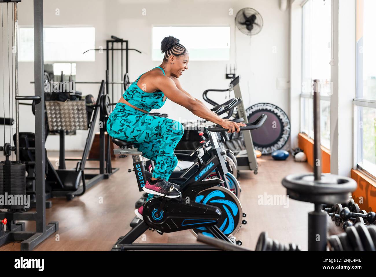 Pretty girl doing exercise on an exercise bike. crossfit gym. Cycling ...