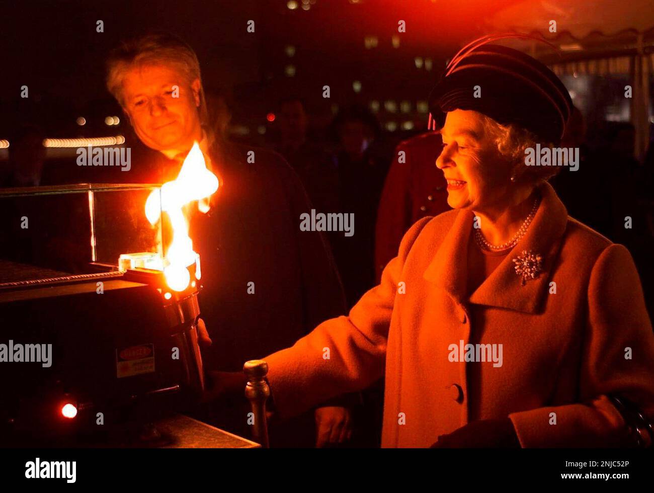 Britain's Queen Elizabeth II lights a beacon floating in the Thames as ...