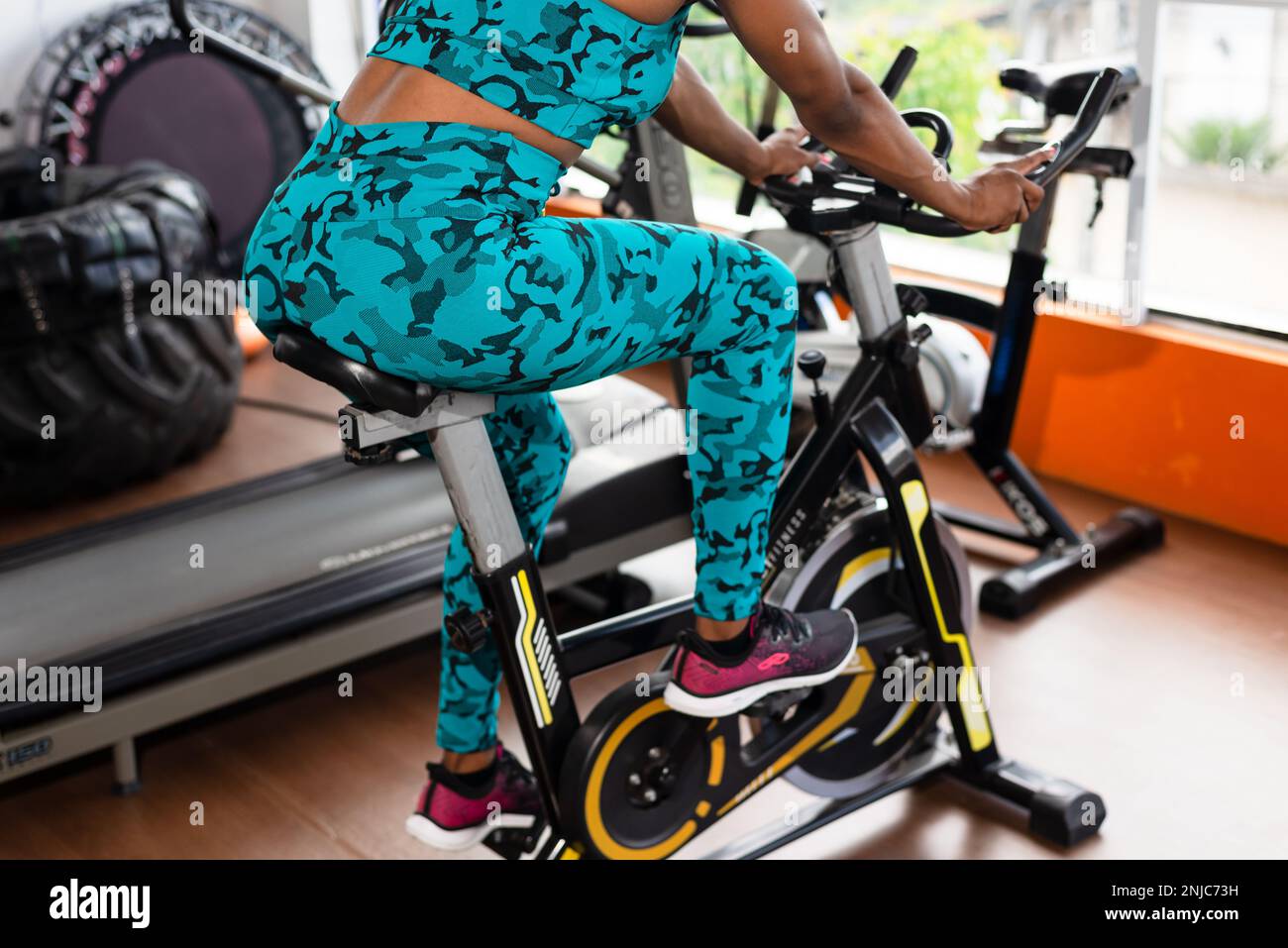 Pretty girl doing exercise on an exercise bike. crossfit gym. Cycling ...