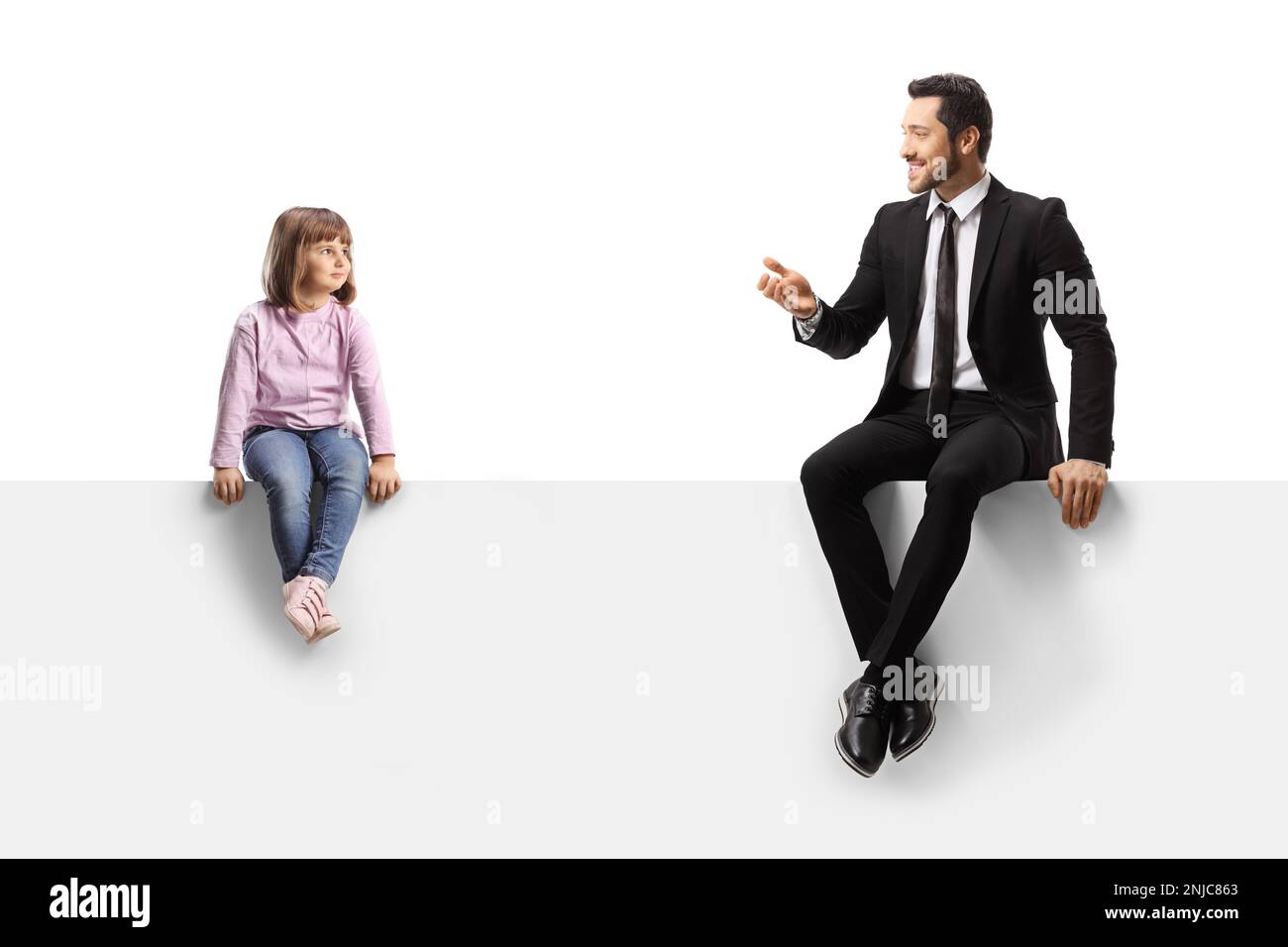 Child sitting on a blank panel and listening to a businessman talking ...