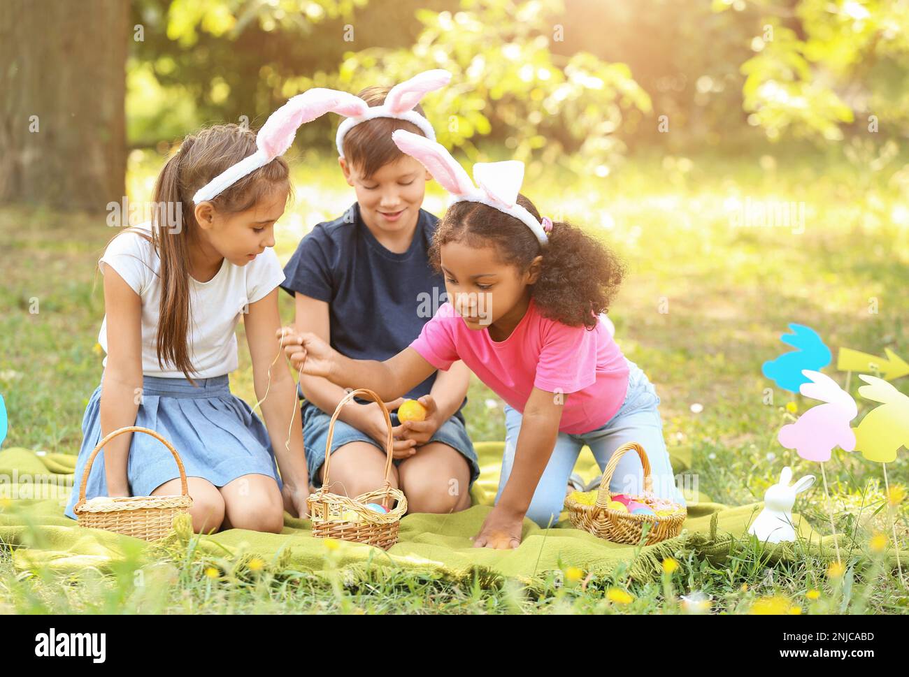 Little children with painted eggs in park. Easter hunt Stock Photo - Alamy