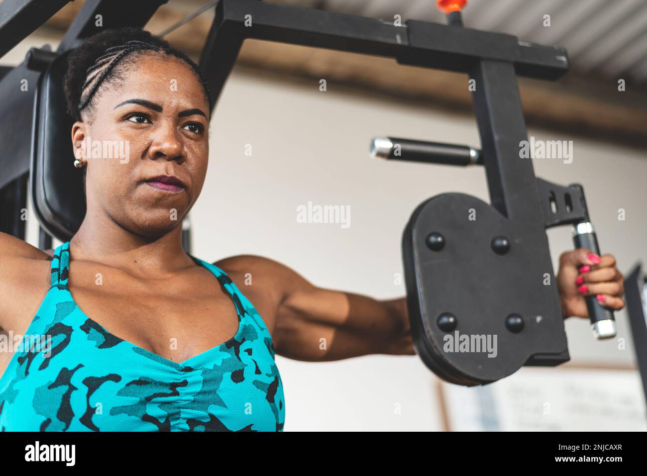Woman sitting on machine doing arm exercises. Fitness in the studio ...