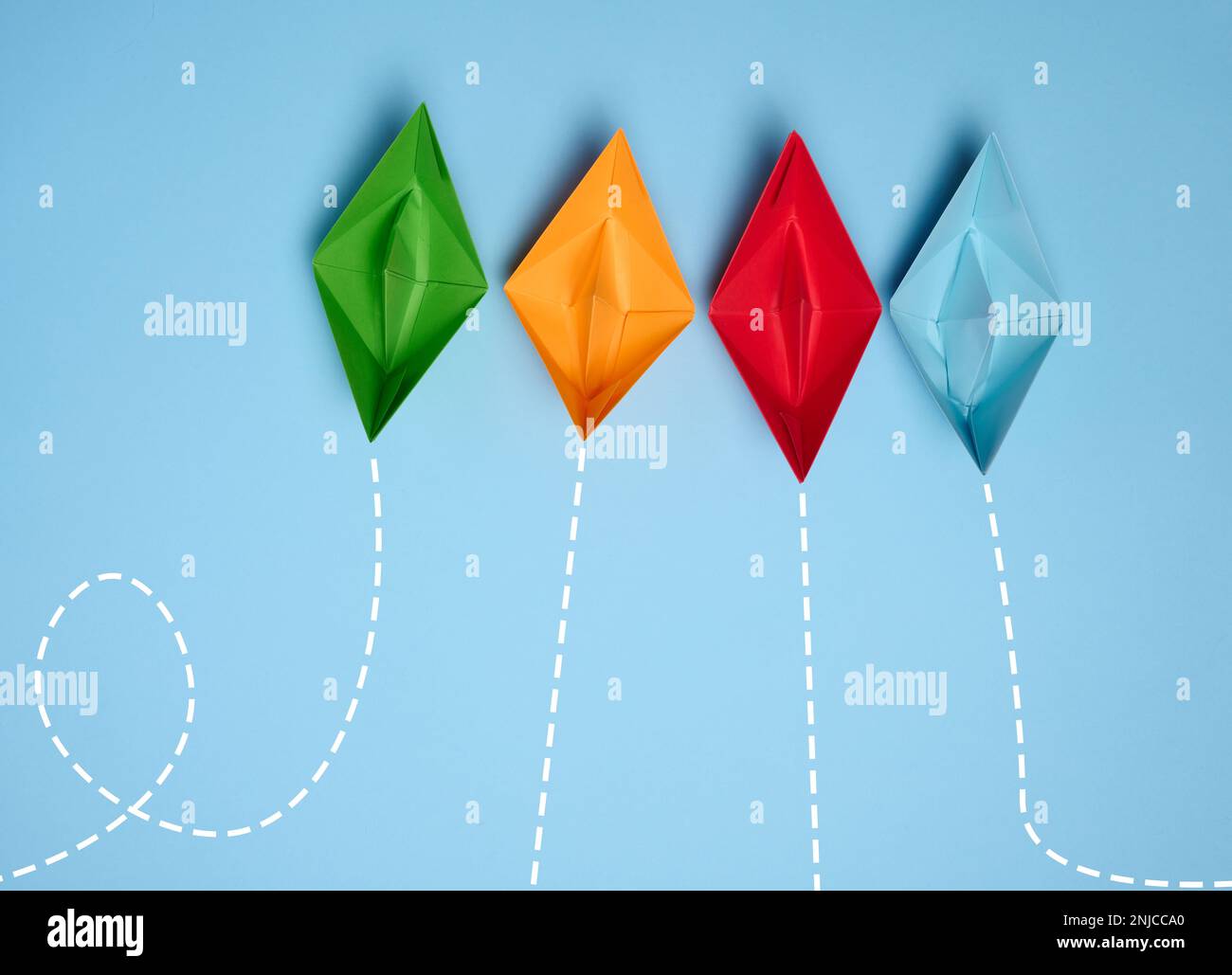 Paper boats on a blue background, representing the concept of ...