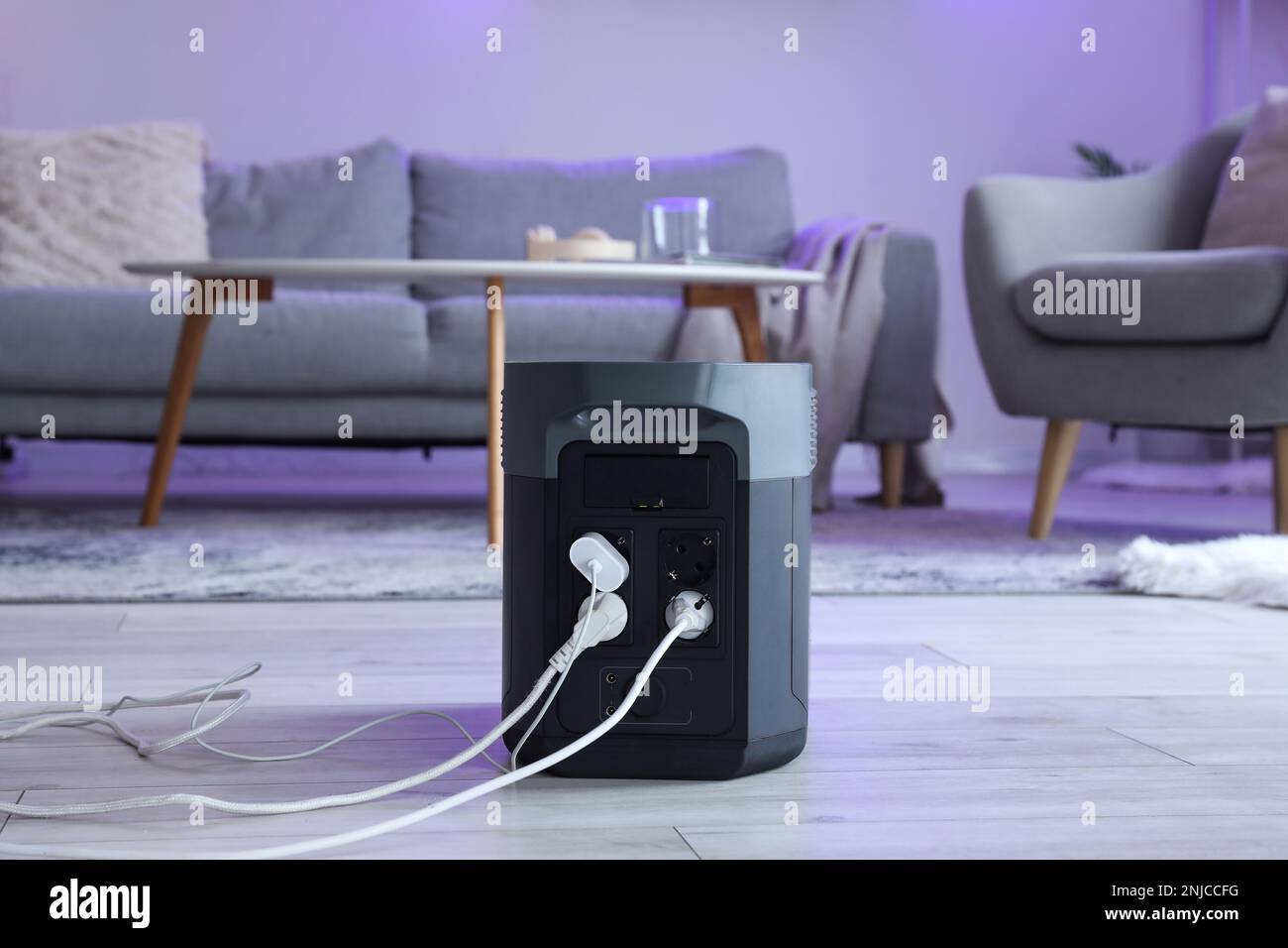 Portable power station charging devices on floor in living room Stock ...