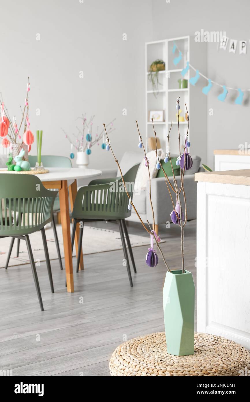 Interior of kitchen with tree branches, Easter eggs and dining table ...