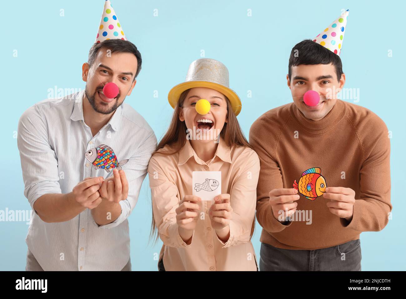Business colleagues with clown noses and paper fishes on blue ...