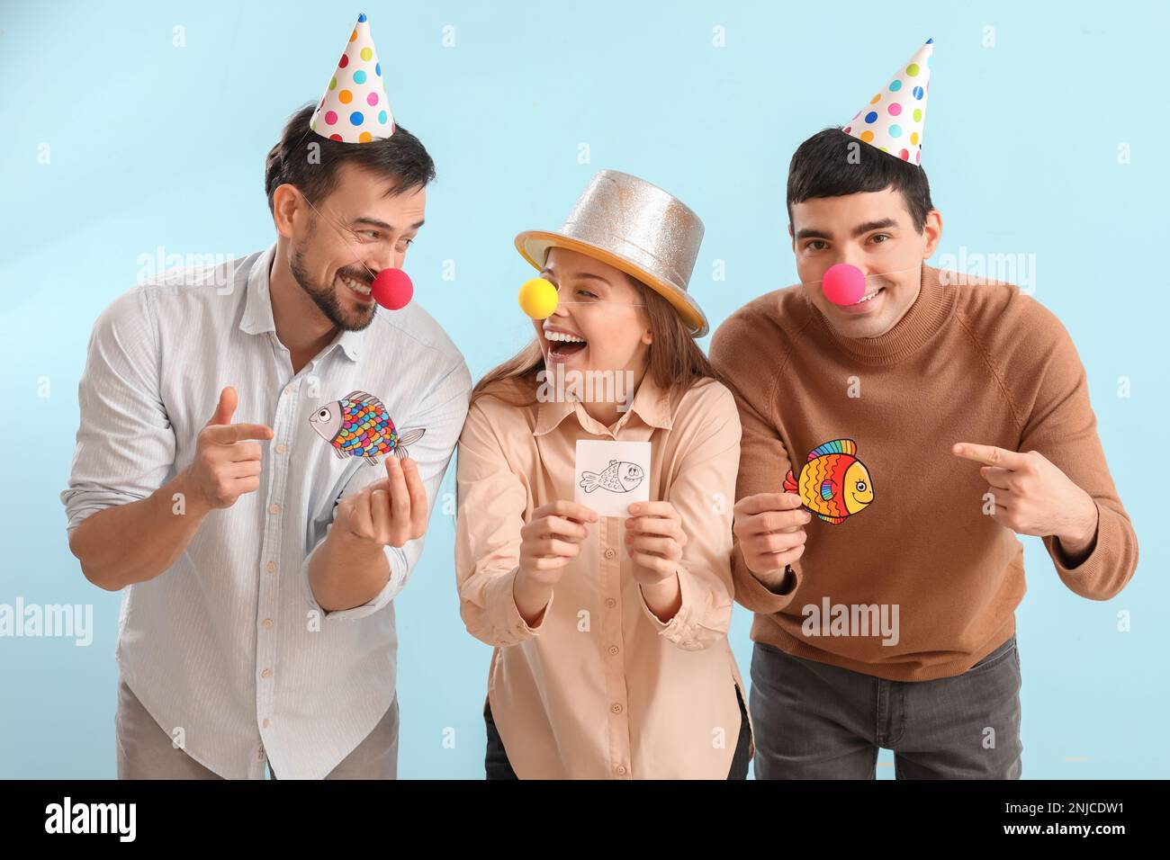 Business colleagues with clown noses and paper fishes on blue ...