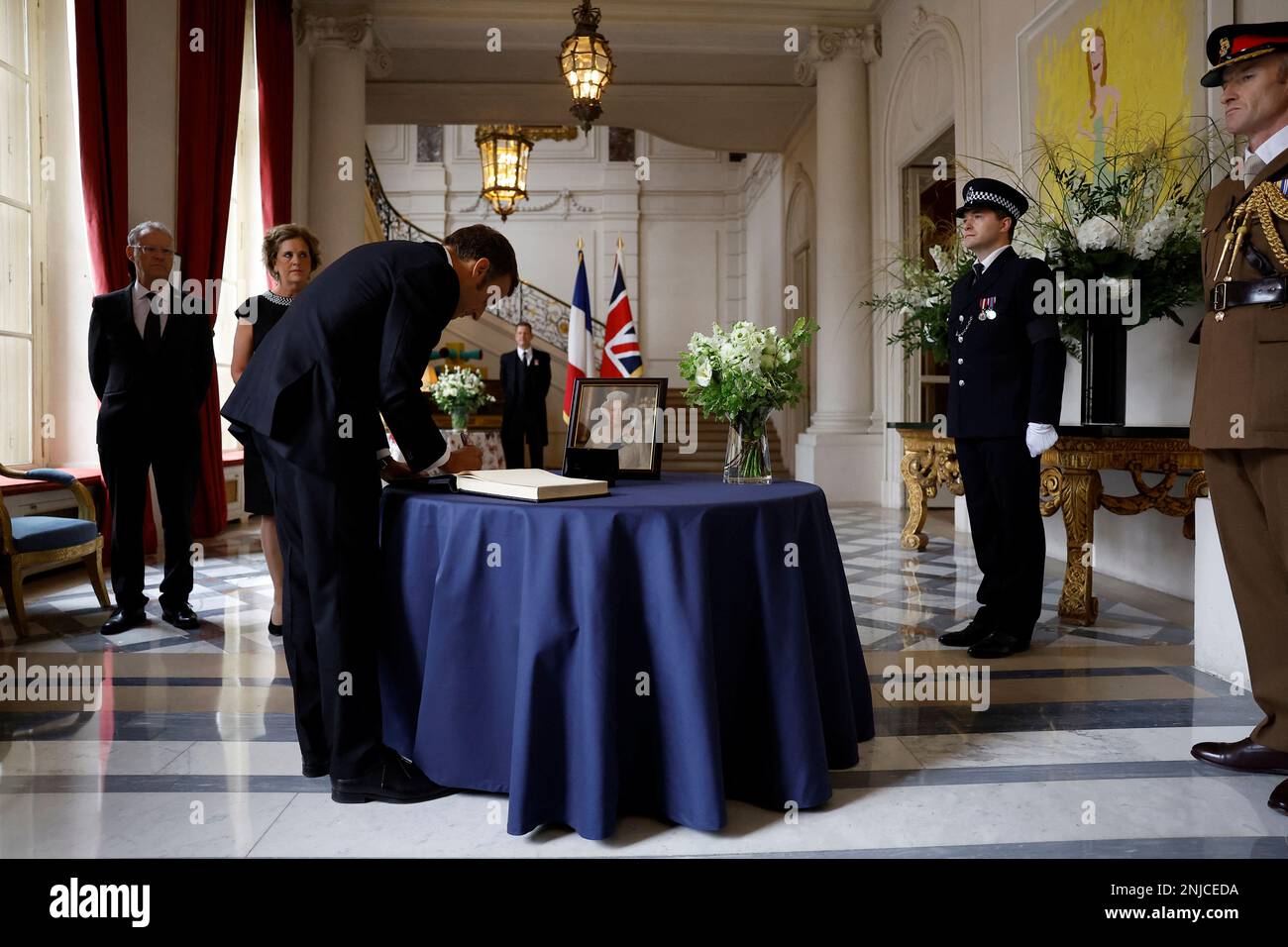 French President Emmanuel Macron signs a condolence book, following the ...