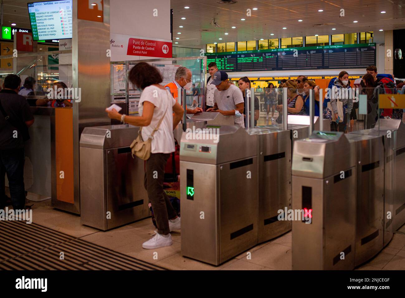 Passengers cross the turnstiles at Sants station, on September 9, 2022 ...