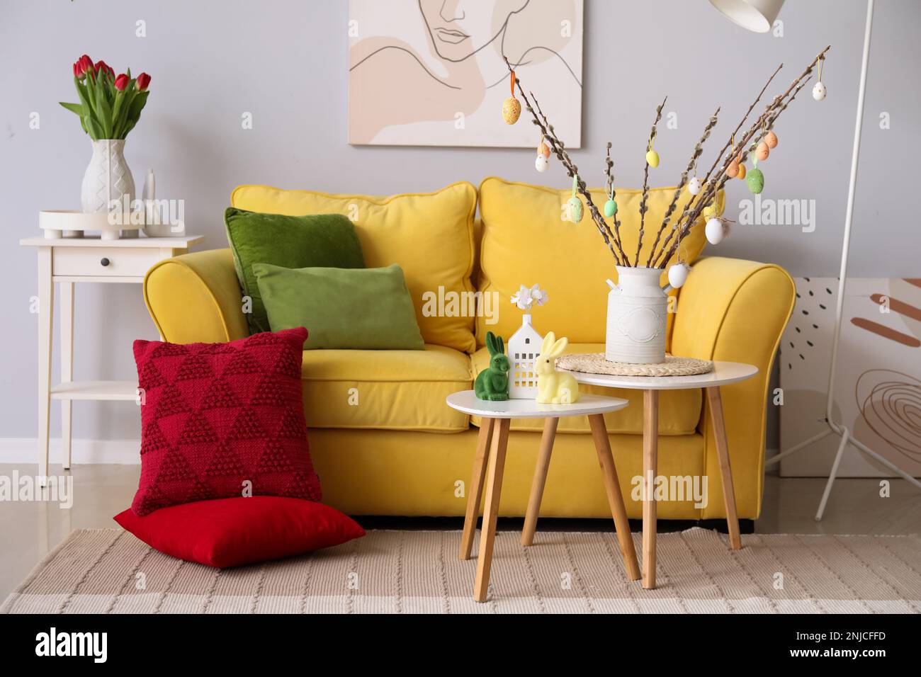 Interior of living room with Easter decor, yellow sofa and tables Stock ...