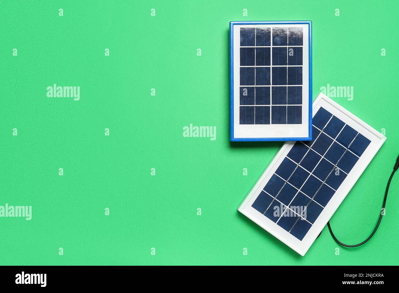 Portable solar panels on green background Stock Photo - Alamy