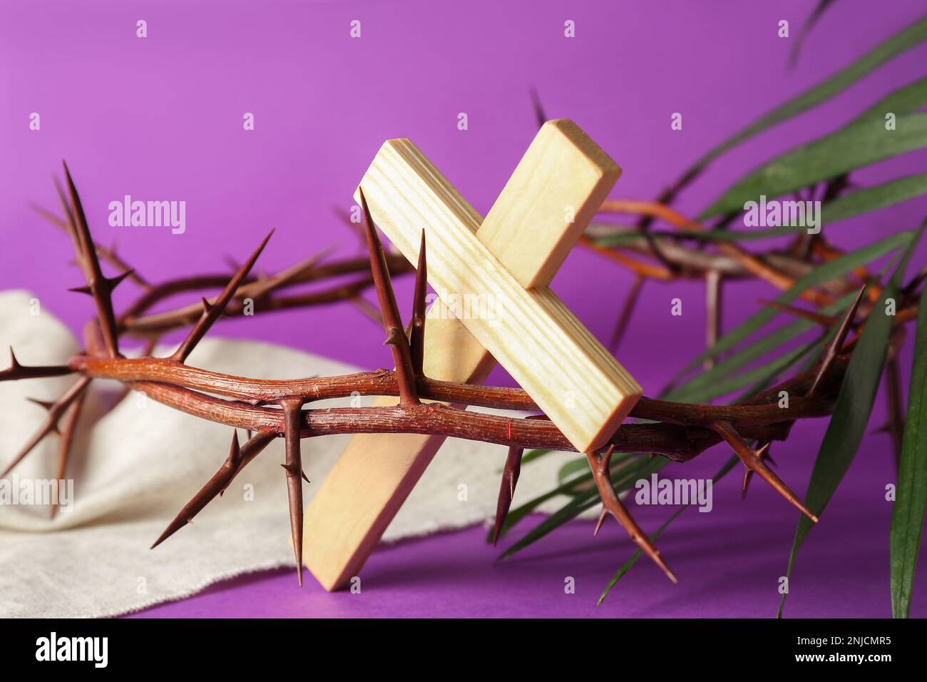 Crown of thorns with wooden cross and shroud on violet background ...