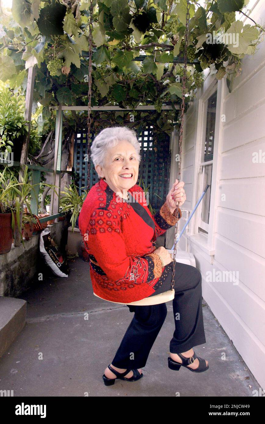 ITALIANS-C-12JUL02-DD-LH--Agnes Piva on a swing under grape vines in ...