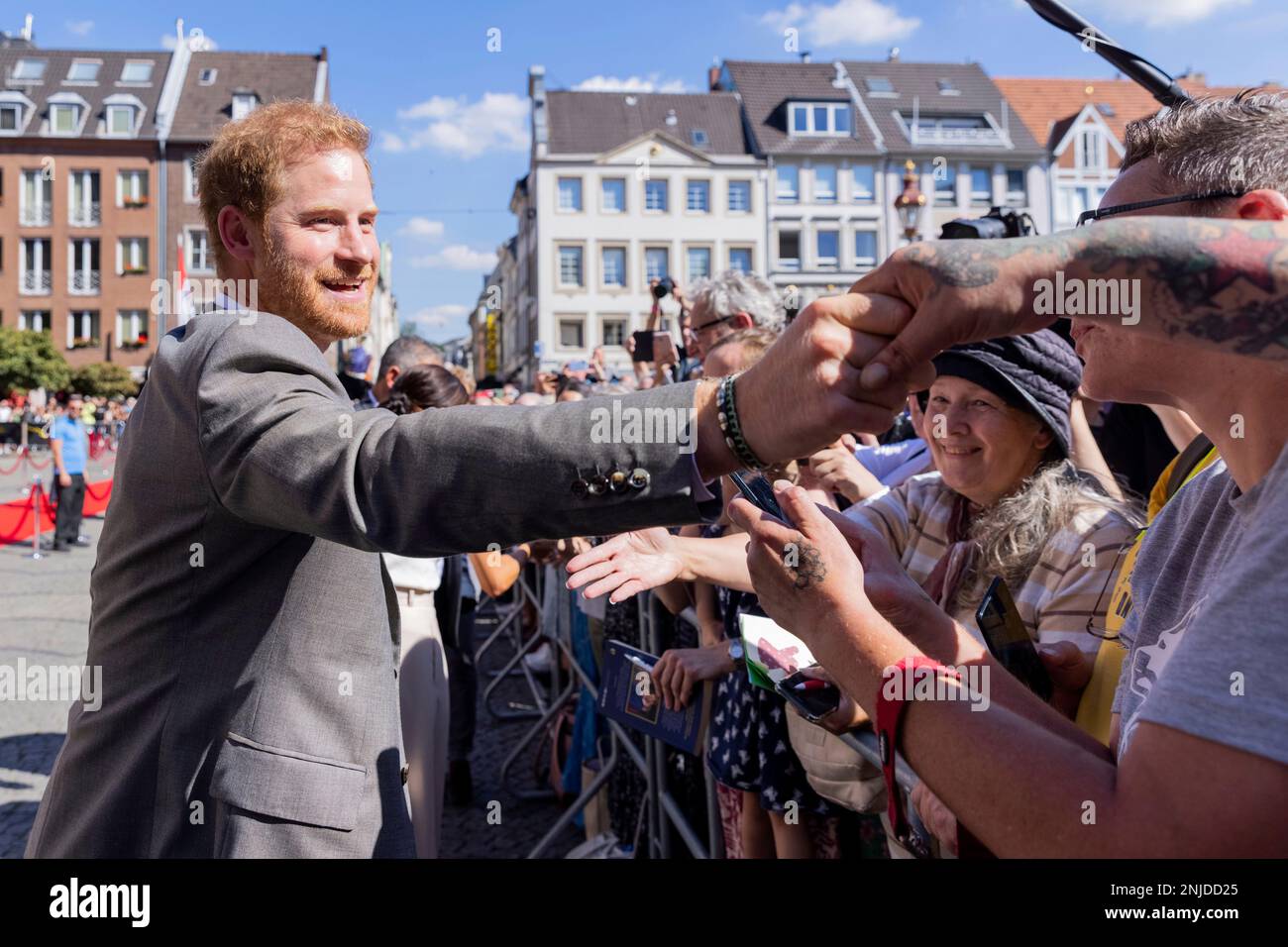 Britain's Prince Harry, left, shakes hand with spectators after a visit ...