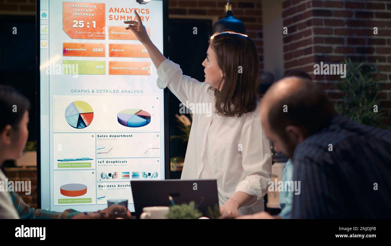 Businesswoman speaking in business meeting, holding laptop, employee ...