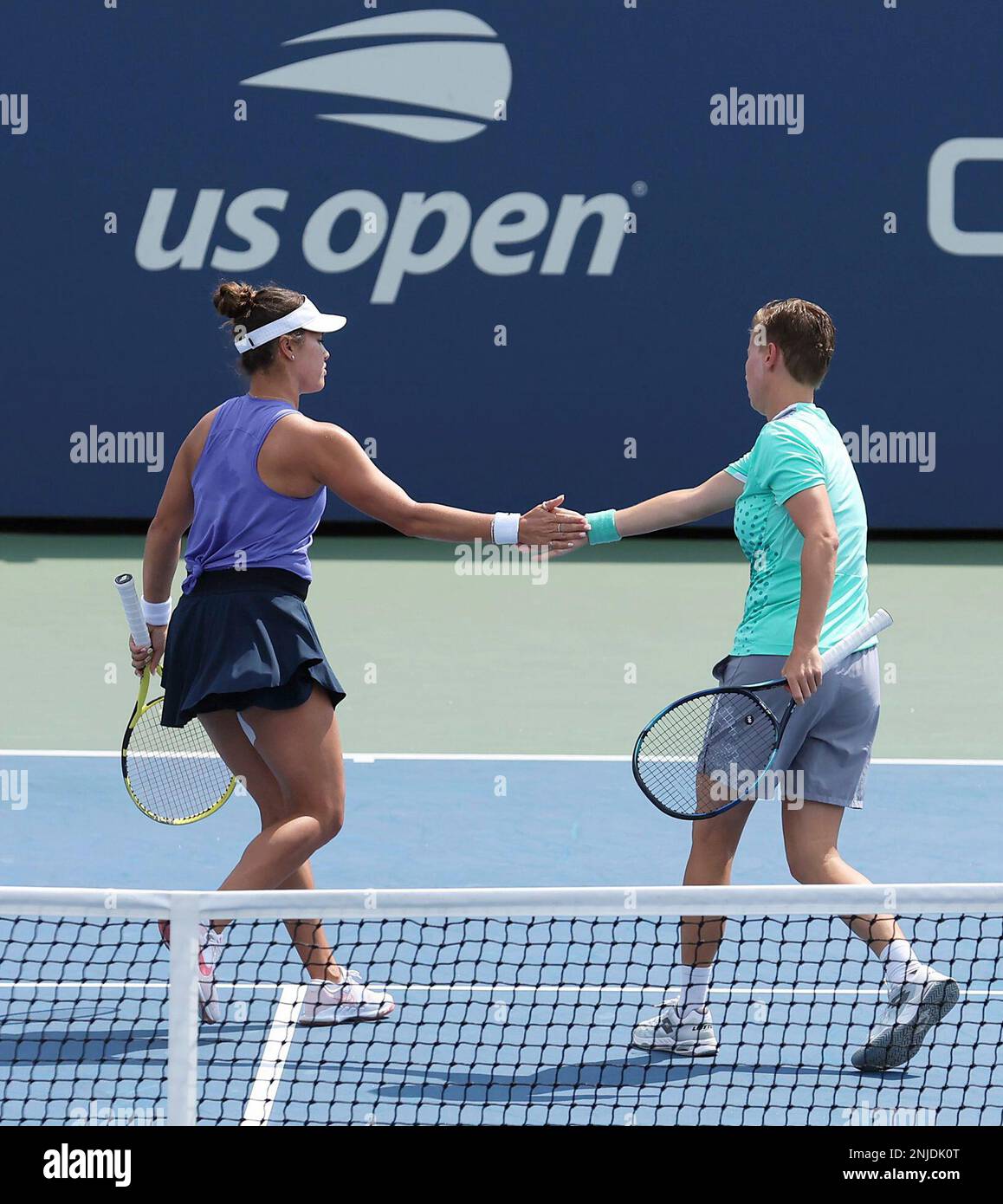 Desirae Krawczyk and Demi Schuurs high five during a women's doubles match at the 2022 US Open ...