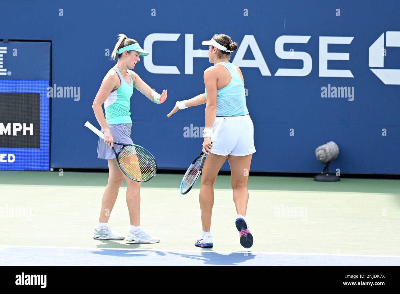 Caroline Dolehide and Storm Sanders high five during a women's doubles ...