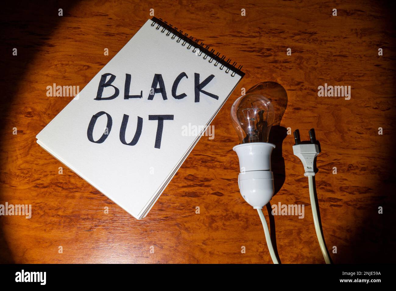 A notepad with the inscription "Blackout" and an electric light bulb in ...